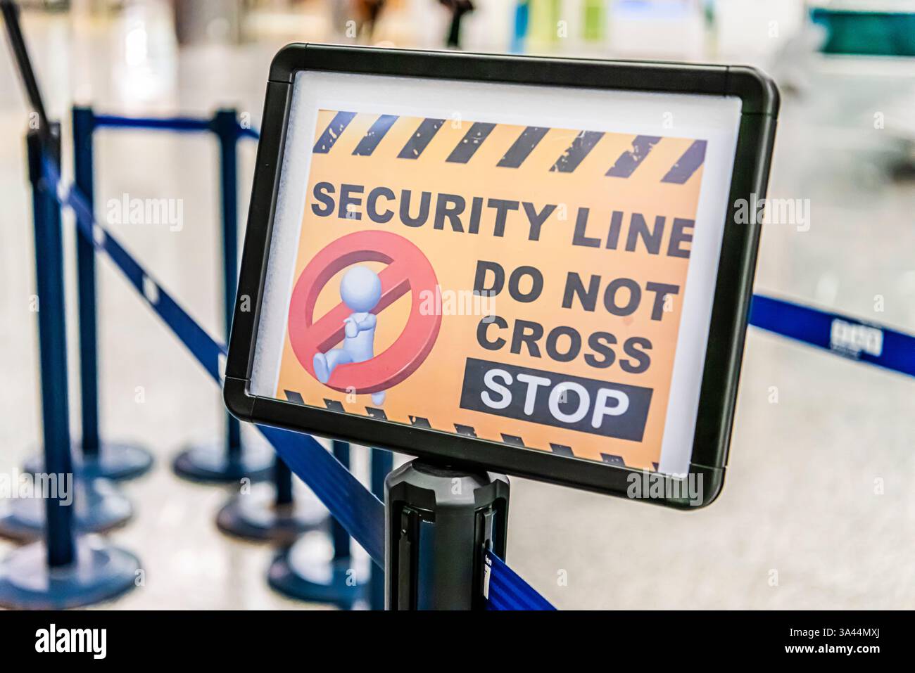 Sign at an airport saying "Security line. Do not cross. Stop Stock ...
