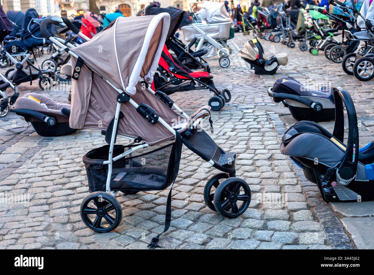 Many empty prams parked on city street paving stone. Lot of baby ...
