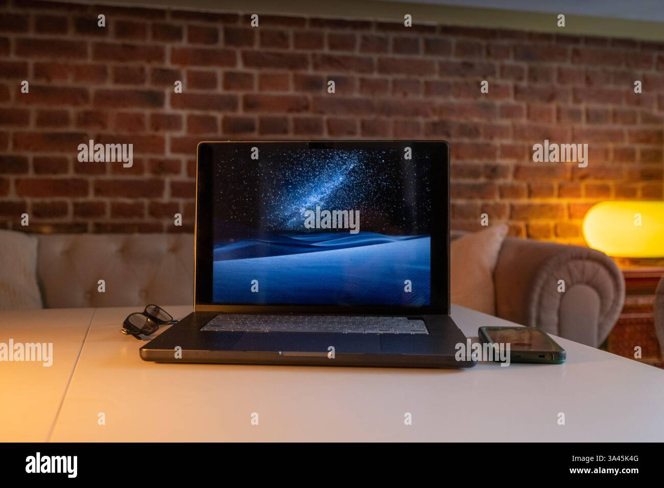 A portable computer is open and on on a table in the living room of a ...