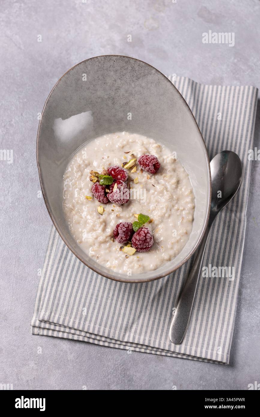 Oatmeal porridge with frozen raspberries and chopped pistachios Stock ...