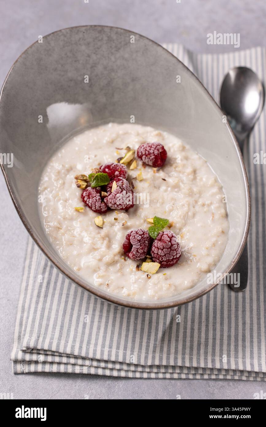 Oatmeal porridge with frozen raspberries and chopped pistachios Stock ...