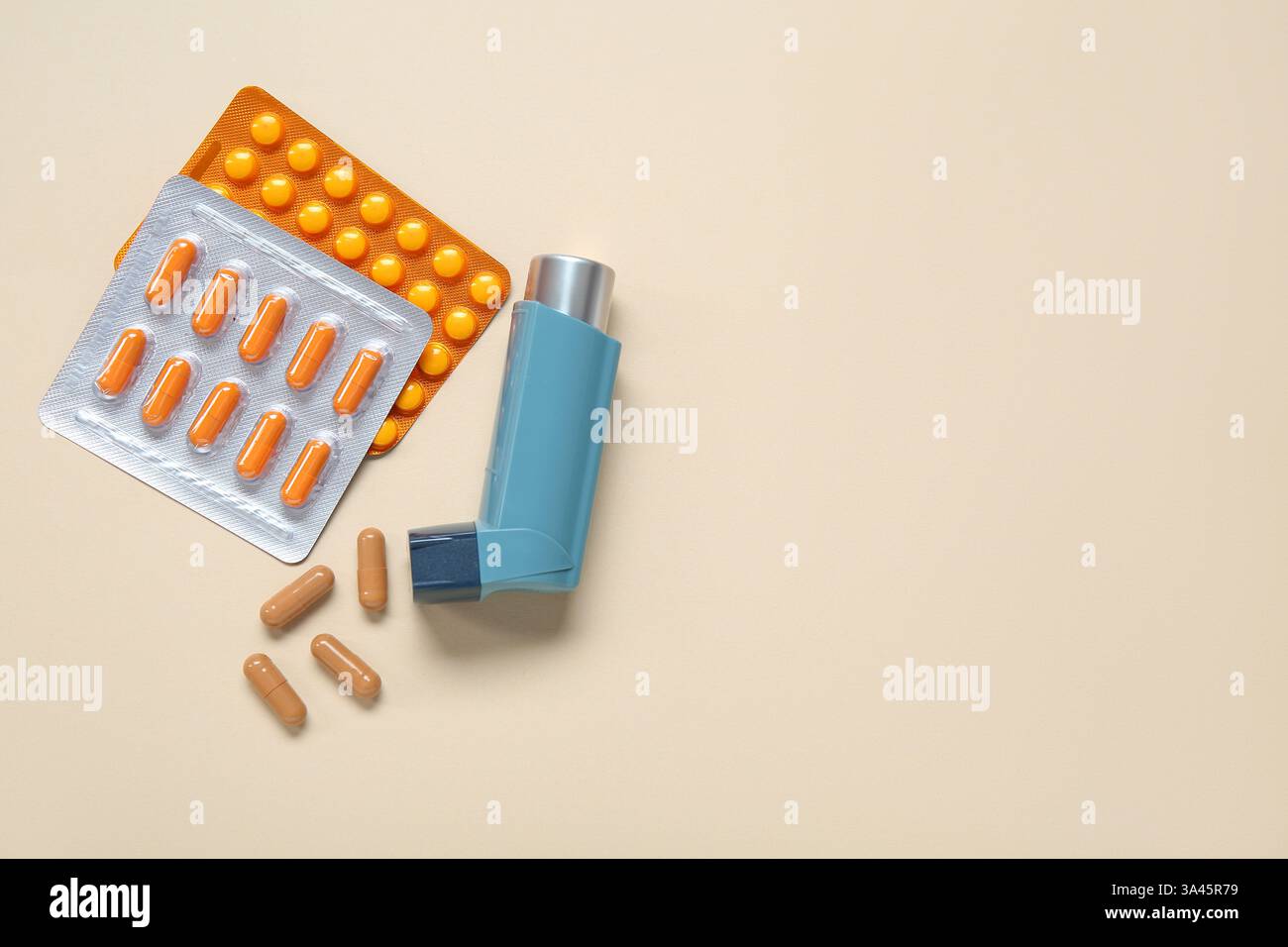 Asthma inhaler and pills on beige background Stock Photo - Alamy