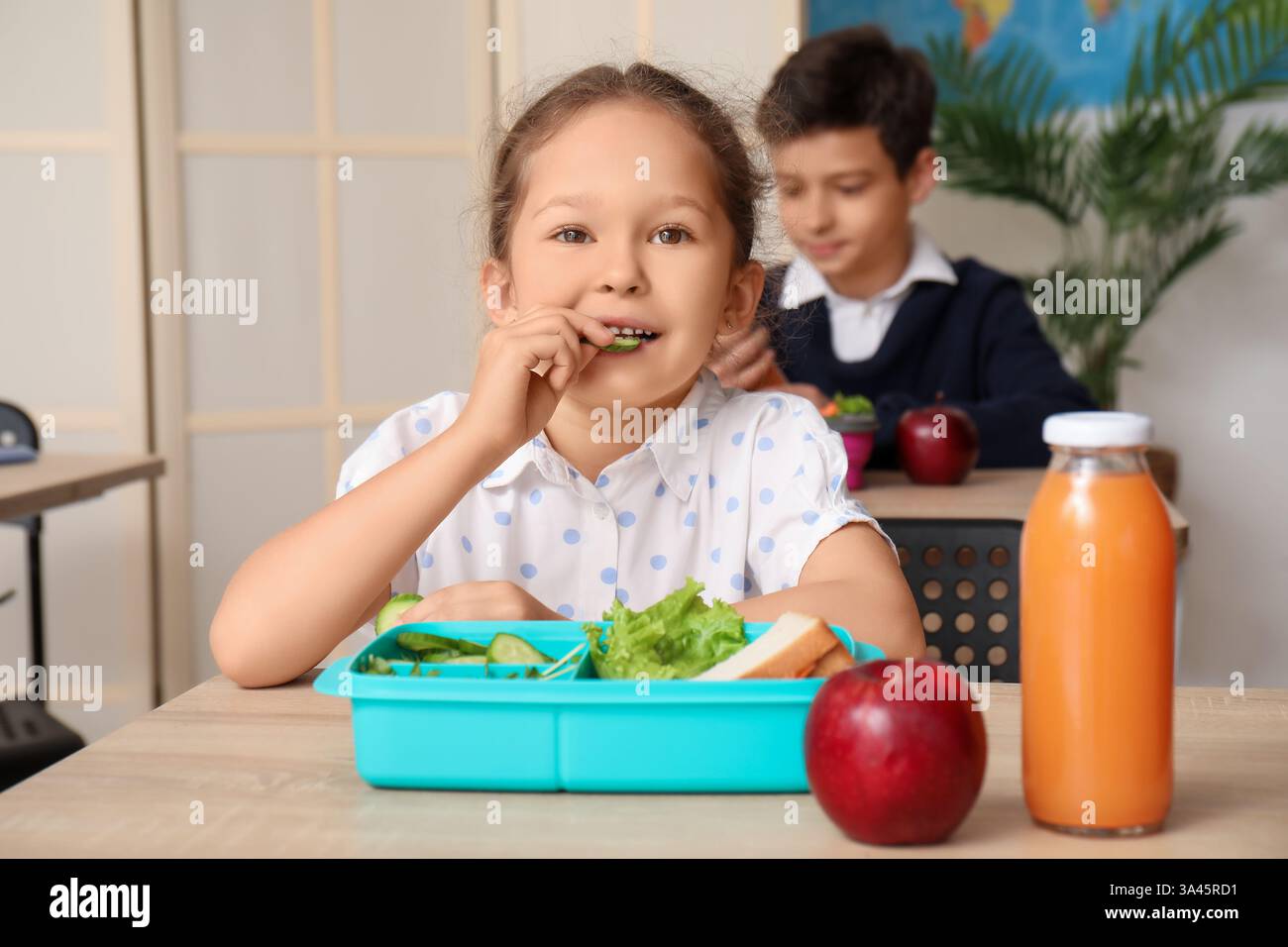 Little girl eating lunch in classroom Stock Photo - Alamy