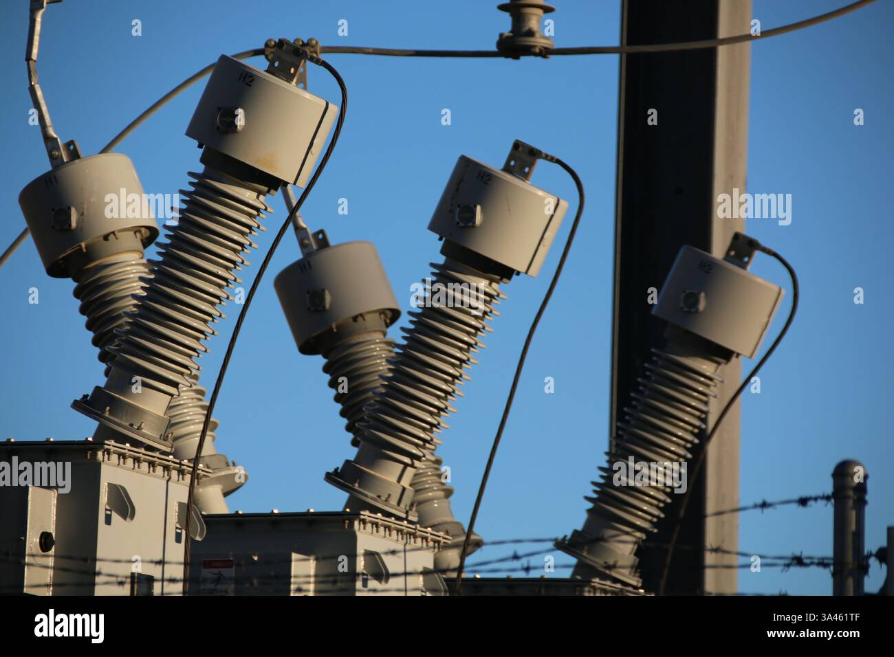 A row of three transformer high voltage bushings on an electrical ...