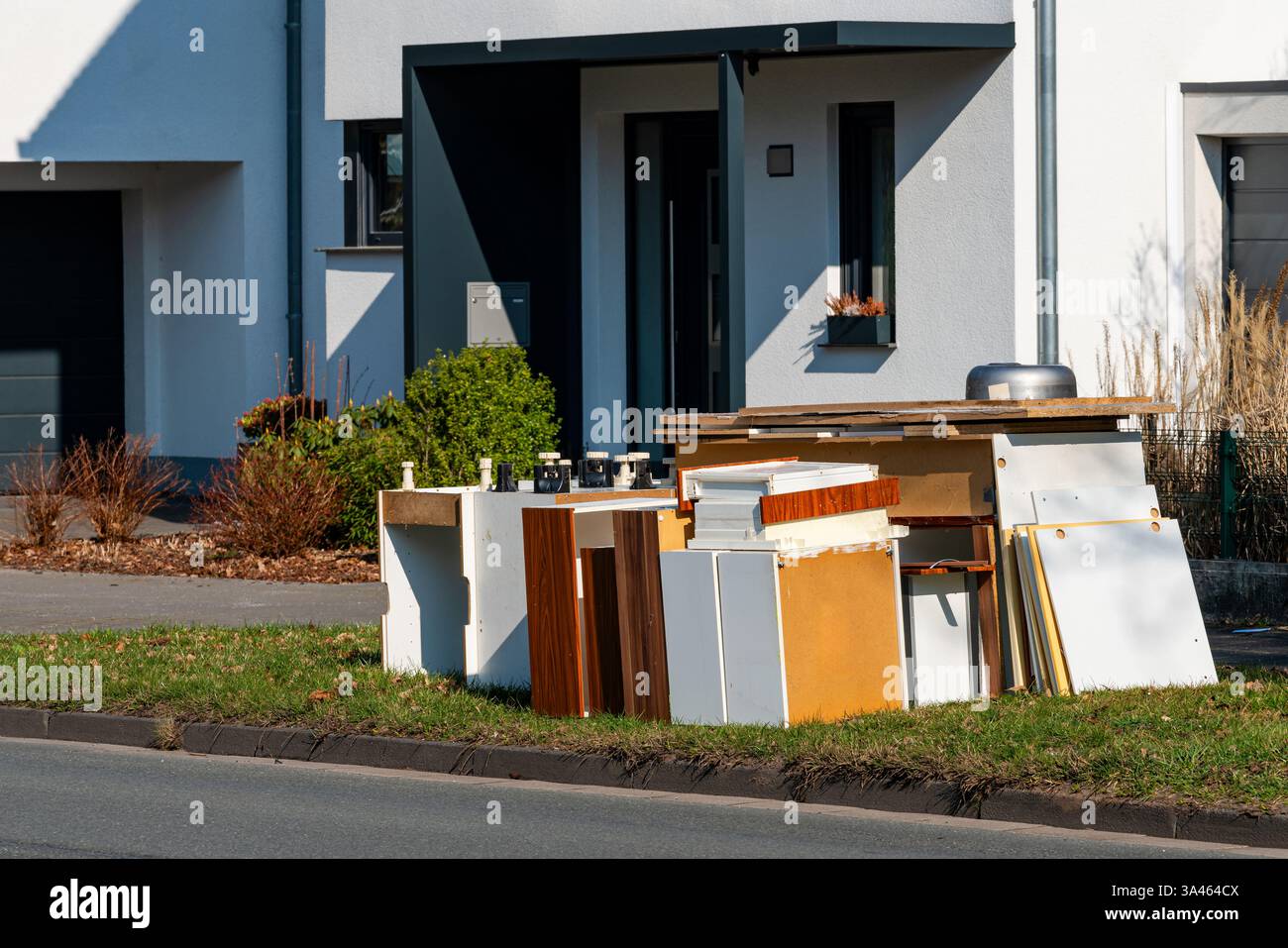 A collection of discarded furniture pieces and wooden materials sits on ...