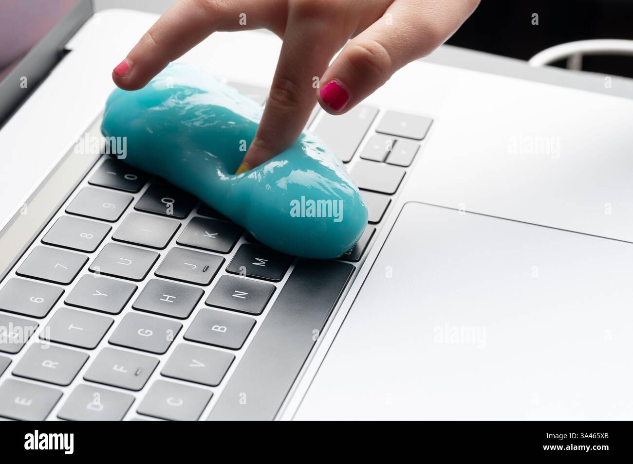 Removing dust from computer keyboard with blue sticky gel Stock Photo ...
