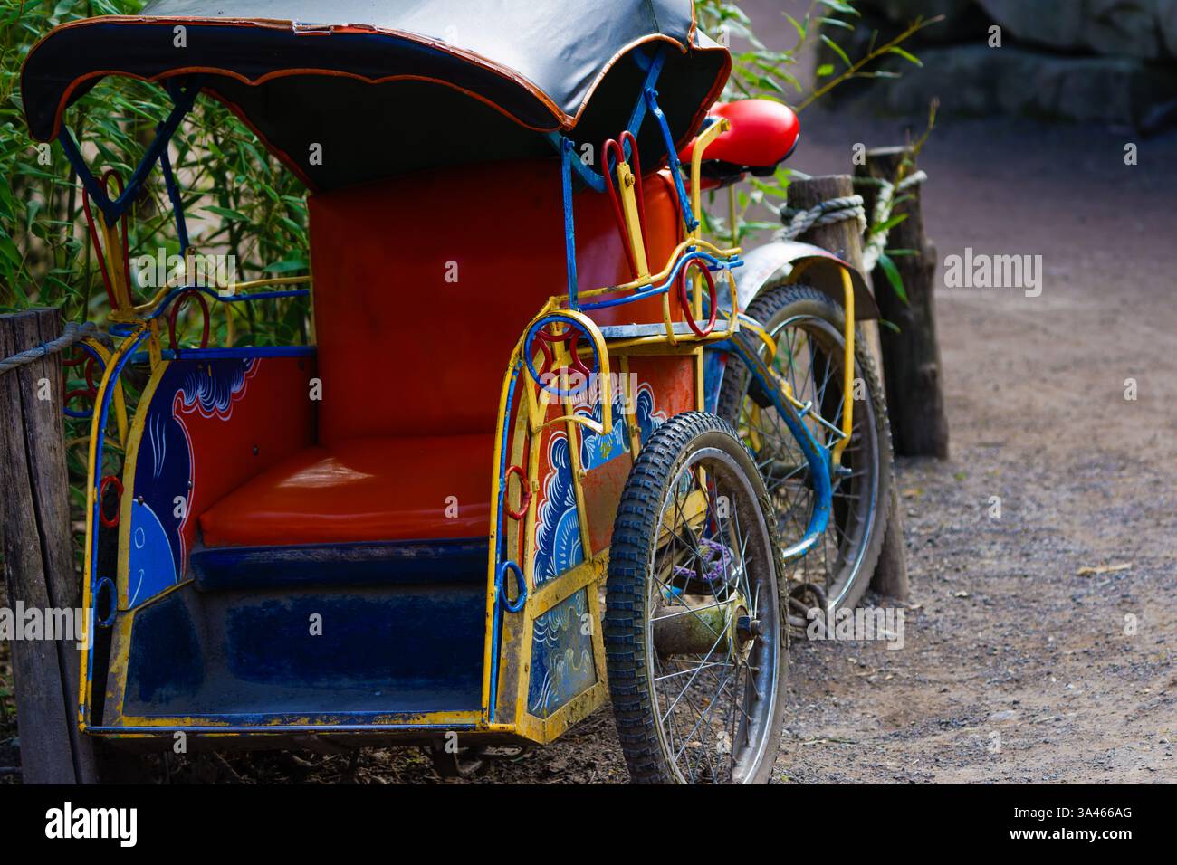Colorful rickshaw with intricate designs parked on a dirt path Stock ...