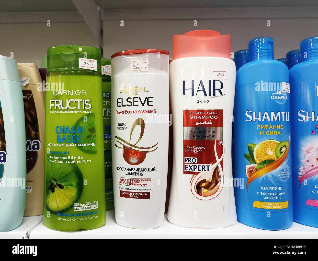 Variety of shampoo bottles on store shelf featuring different brands ...