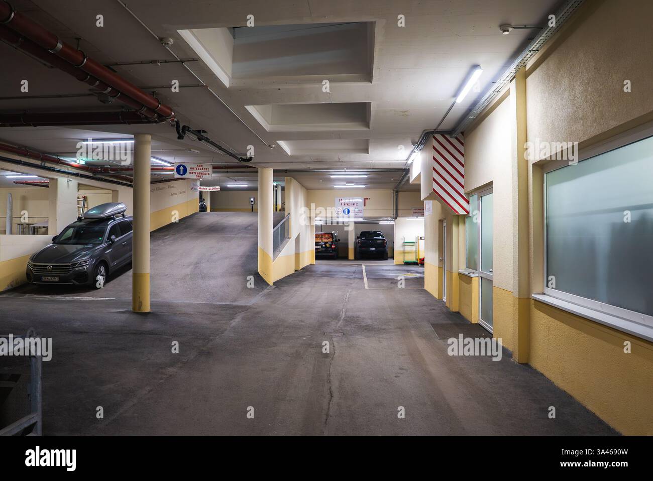 Indoor Parking Garage with Ramp and Directional Signage in Ischgl Stock ...