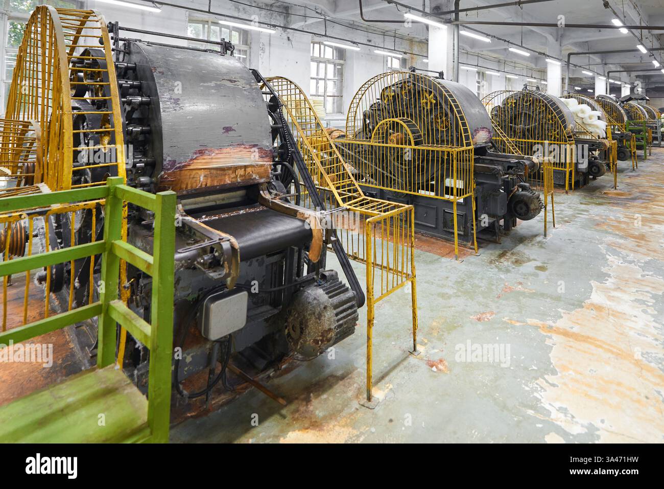 Intricate workings of a vintage carding machine in a textile factory ...