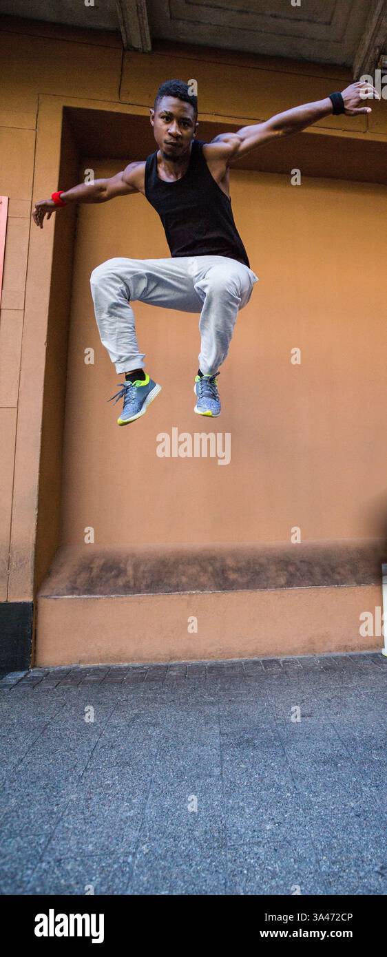 Man performing parkour jump in urban setting, showcasing agility and ...