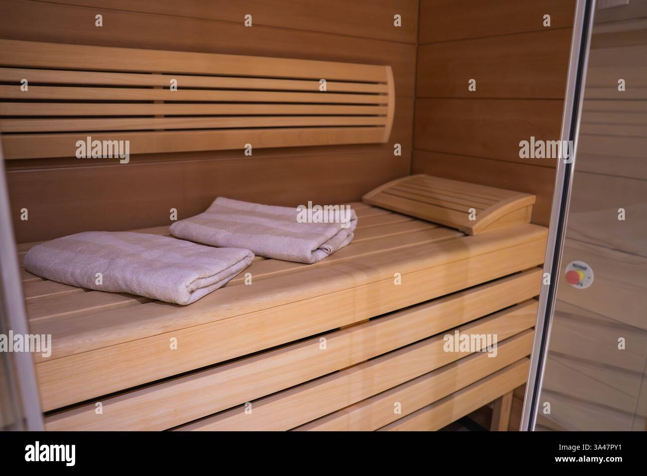 Wooden Sauna Interior with Benches, Towels, and Glass Door Stock Photo ...