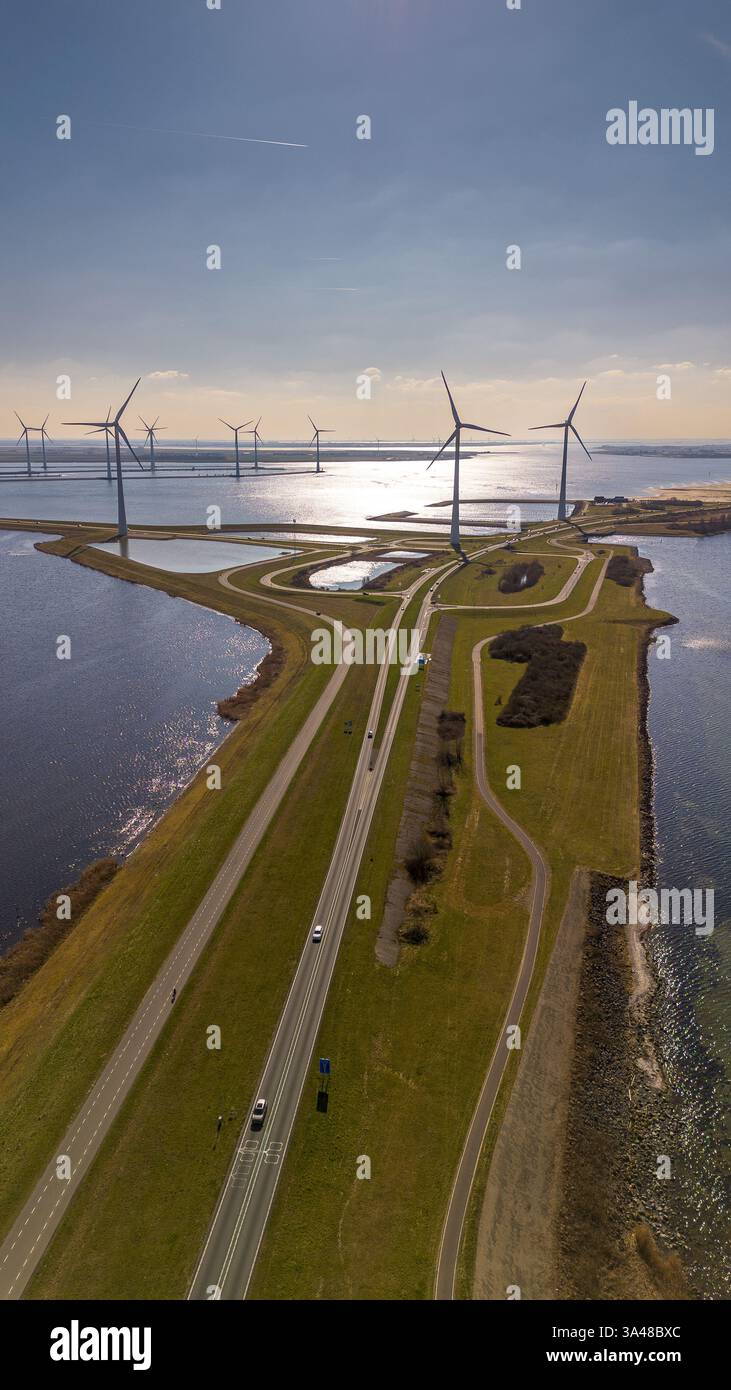 A scenic aerial view of a coastal wind farm with multiple wind turbines ...