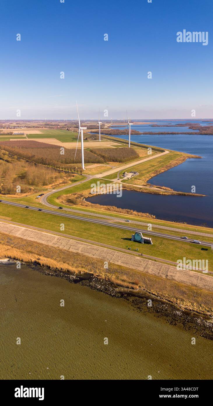 A scenic aerial view of a coastal wind farm with multiple wind turbines ...