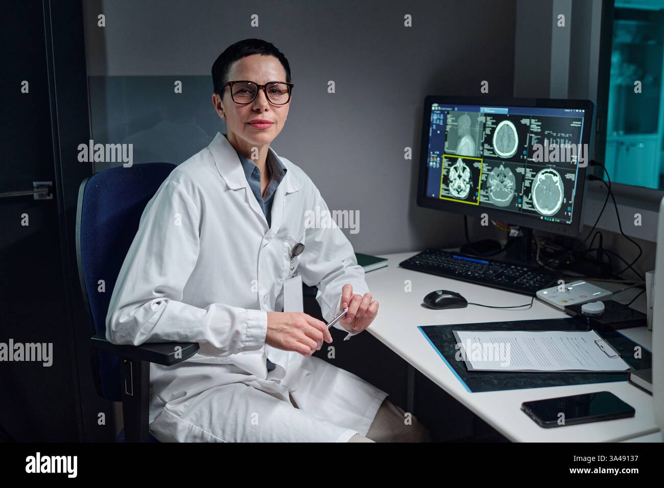 Portrait of scientist in laboratory holding glasses while analyzing data on computer screens ...