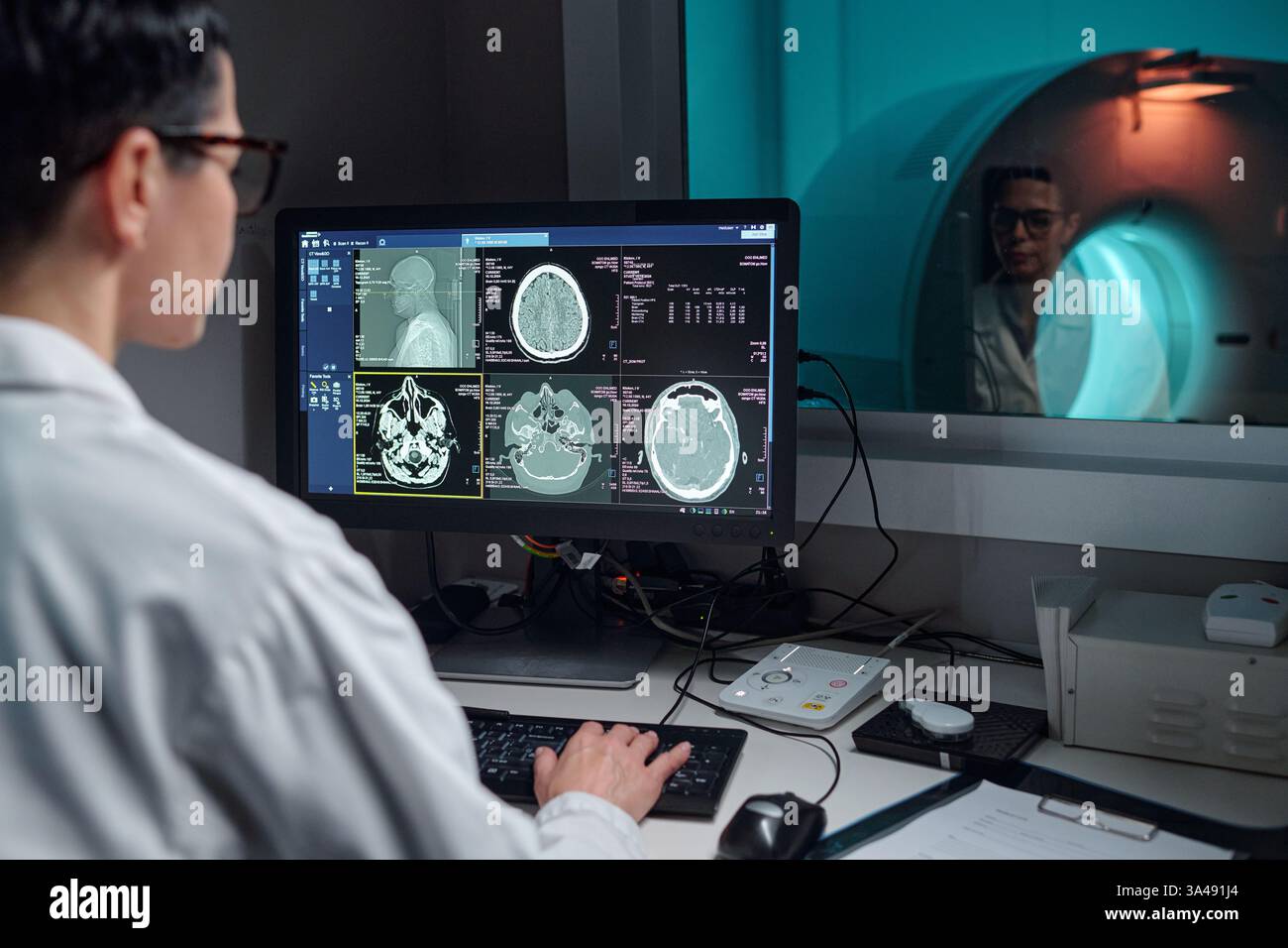 Professional medical technician analyzing brain scans on high-tech ...