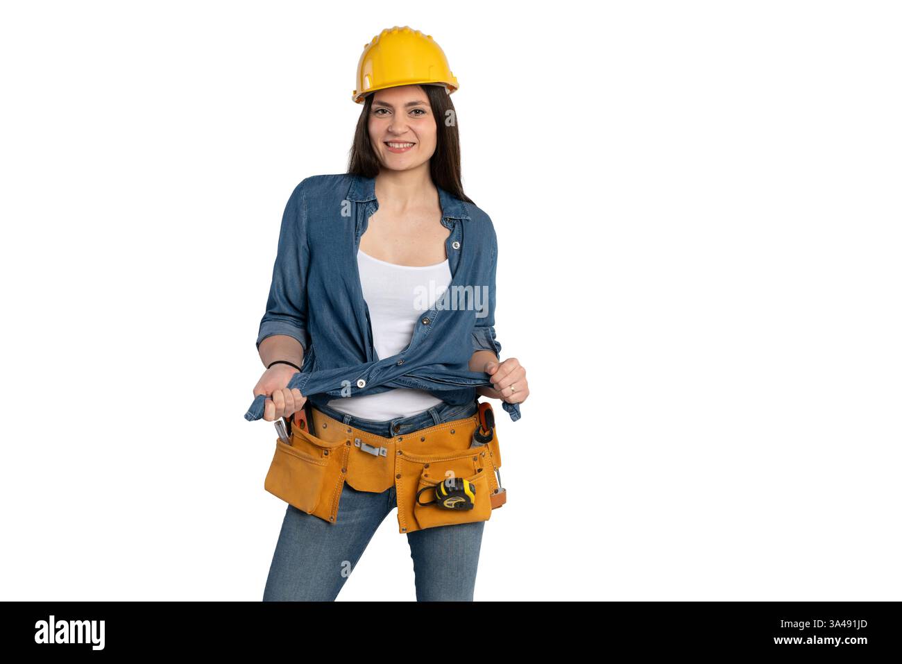 Young female construction worker wearing a yellow hard hat and tool ...