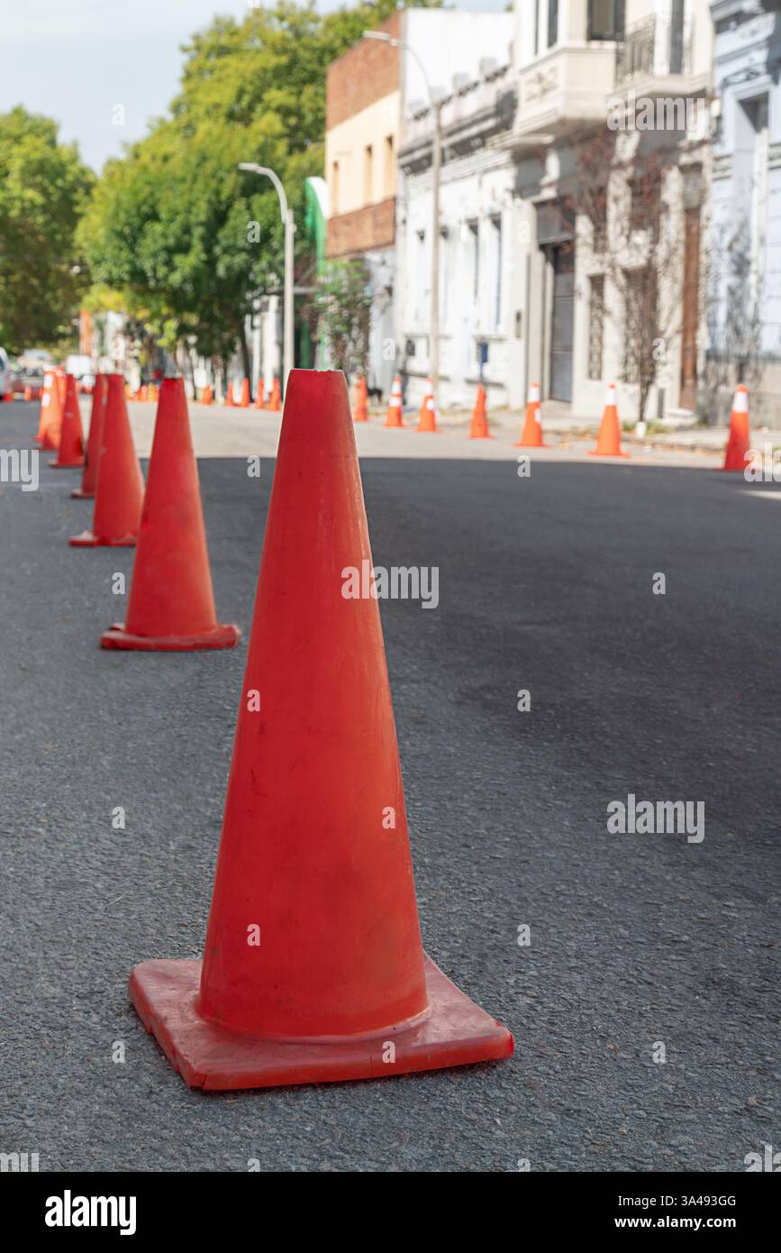 Orange and white traffic cones lining an empty city street Stock Photo ...