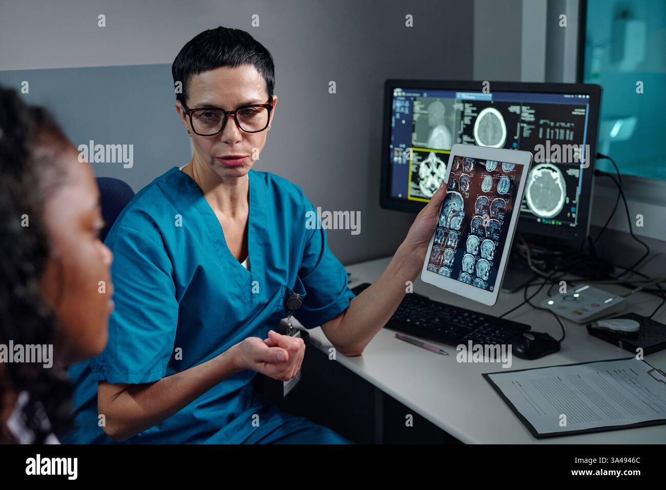 Medical professional explaining diagnostic imaging results displayed on ...