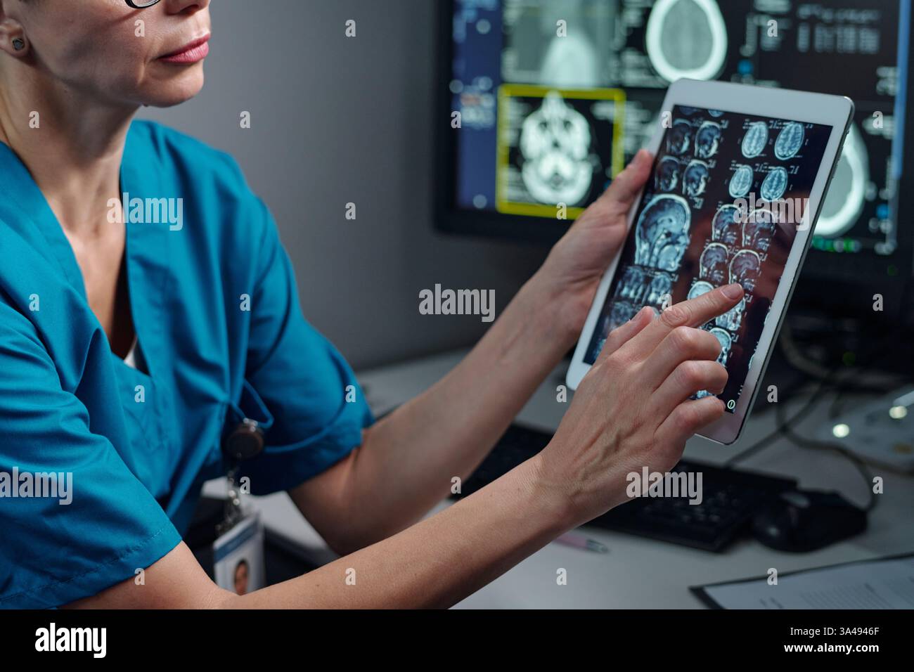 Medical professional analyzing brain scans on tablet device in modern ...