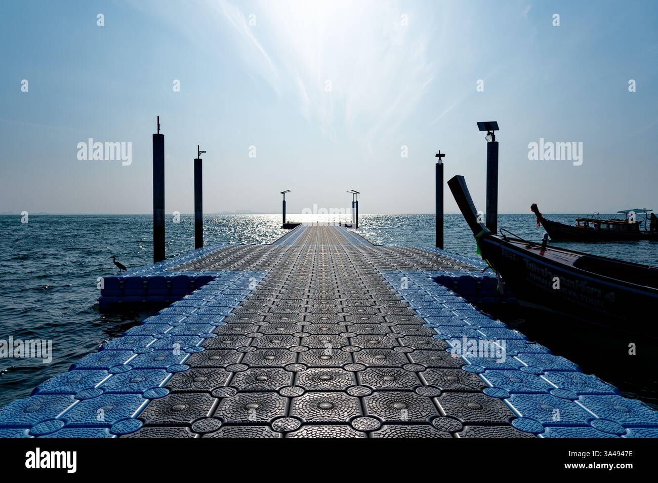 Floating pier extends into the sea at Railay, glowing under the hard ...