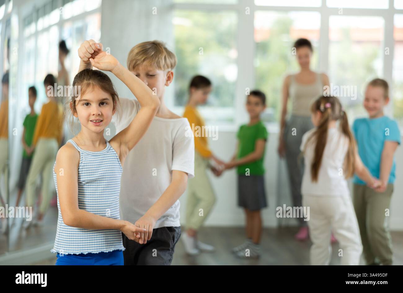 Happy preteen children practicing ballroom dances in pairs in training ...