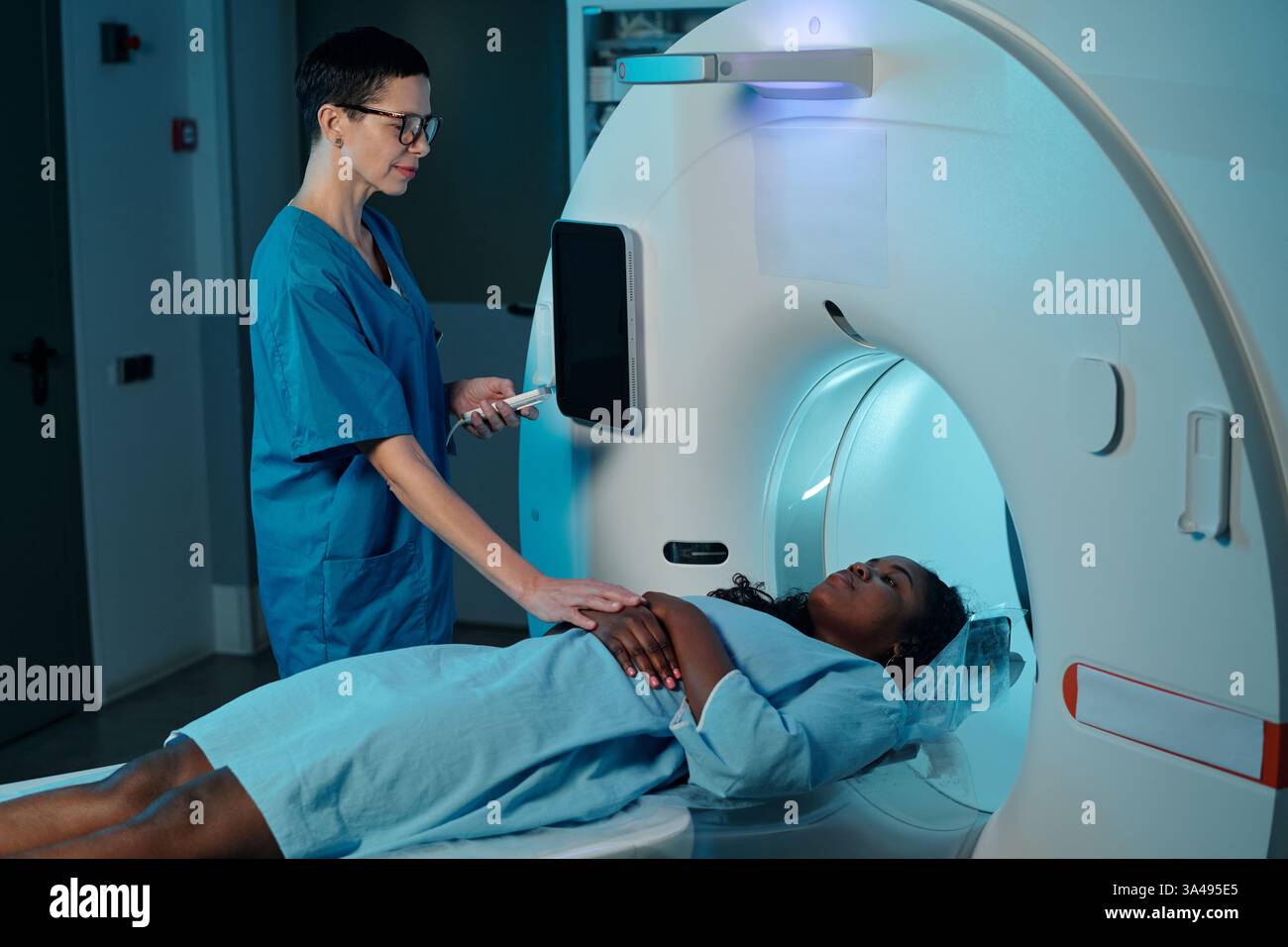 Medical technician conducting MRI scan for patient in hospital setting ...