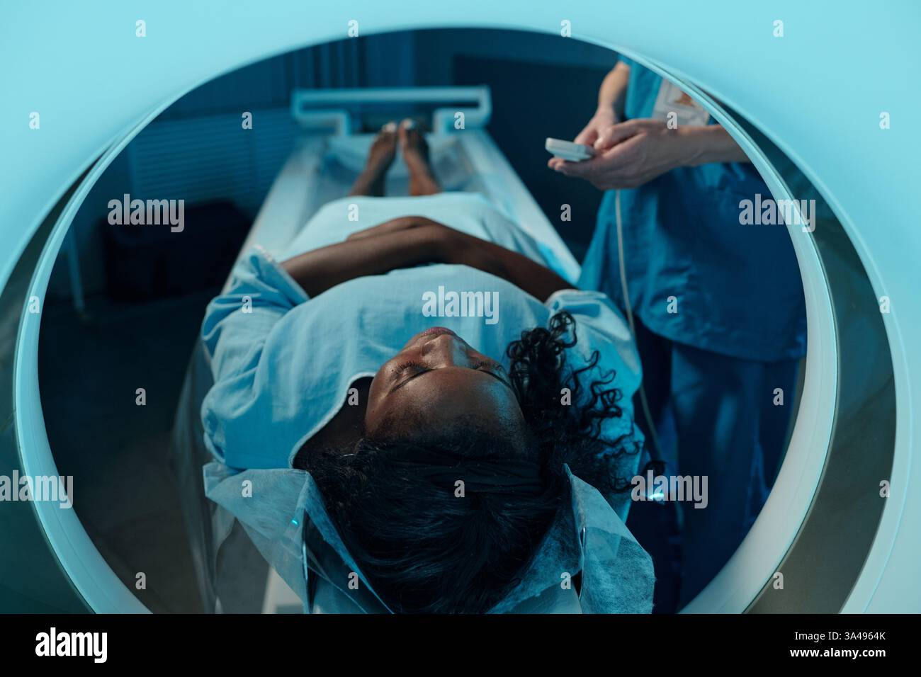 Medical professional monitoring African American patient during MRI ...