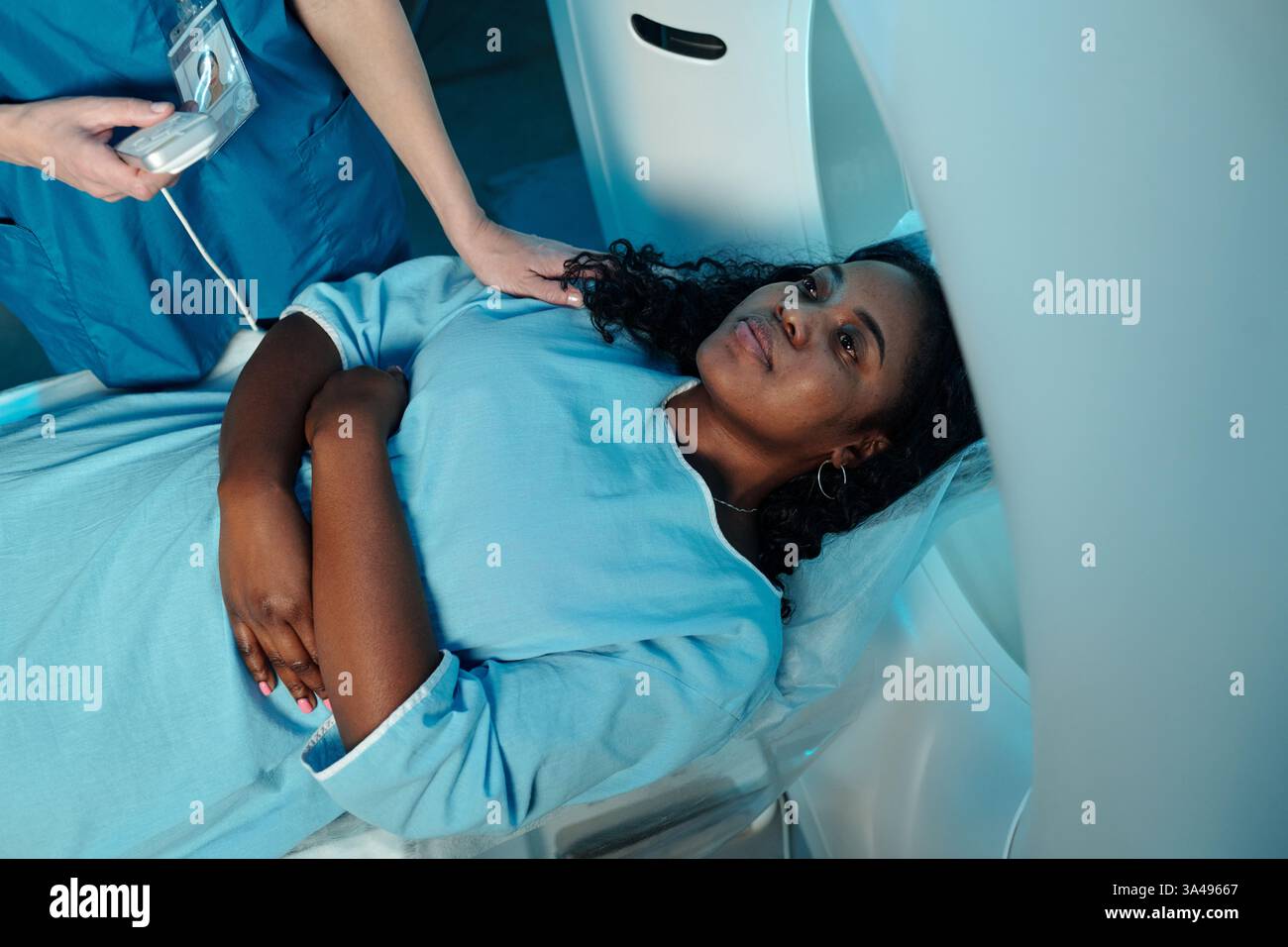 African American woman receiving medical scan in modern facility lying ...