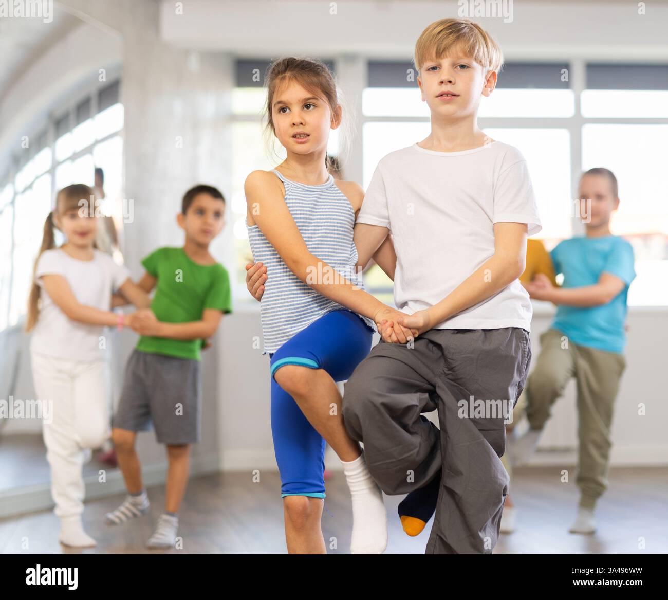 Positive juvenile boy and girl engaged in Rock 'n' Roll dance during ...