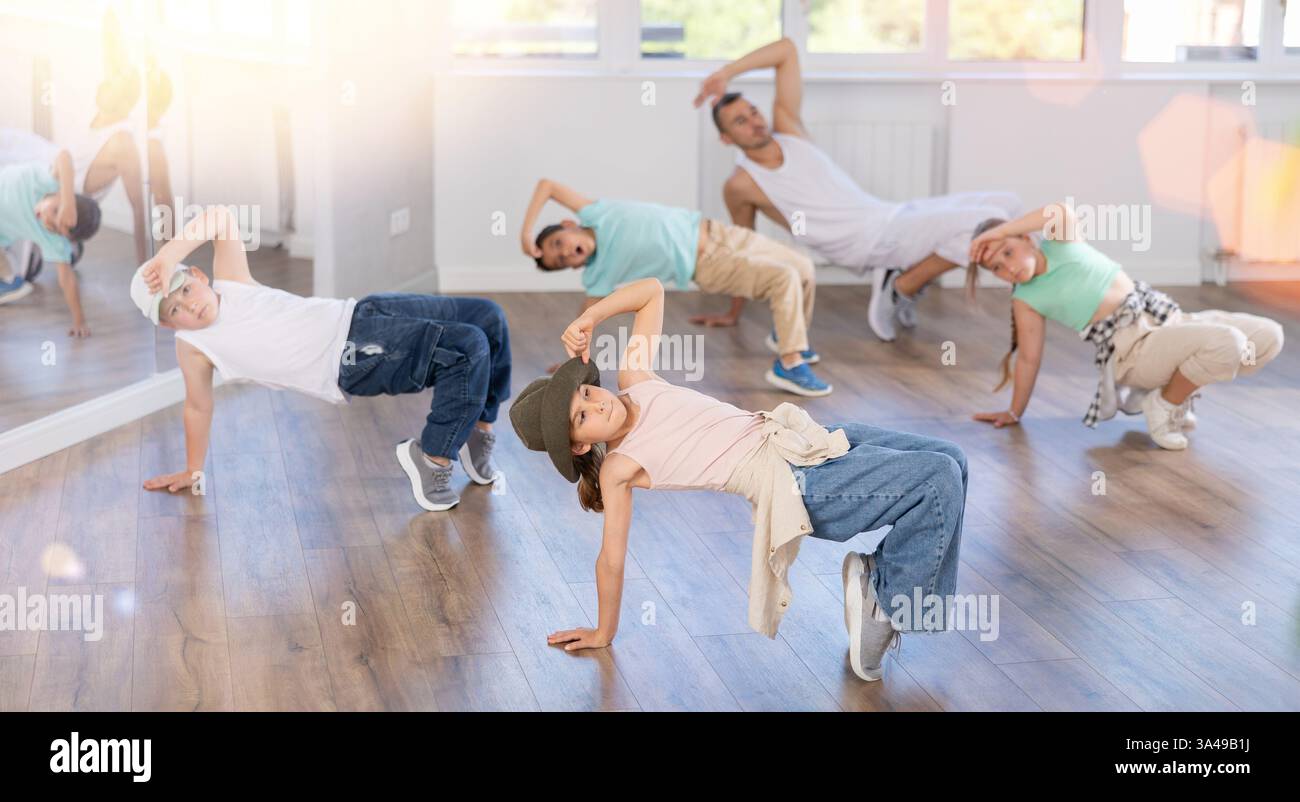 Preteen boys and girls studying movement of contemporary dance in ...