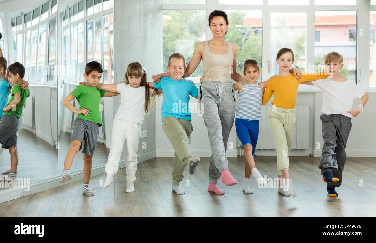 Preteen children and doing cancan dance together with female trainer ...