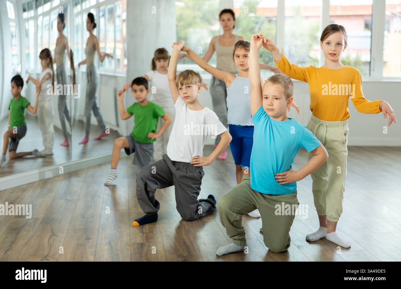 Happy preteen children practicing ballroom dances in pairs in training ...