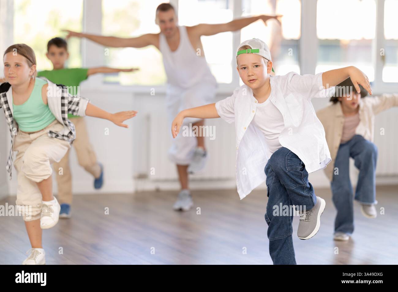 Children practicing hip-hop dance in training hall during group dancing ...