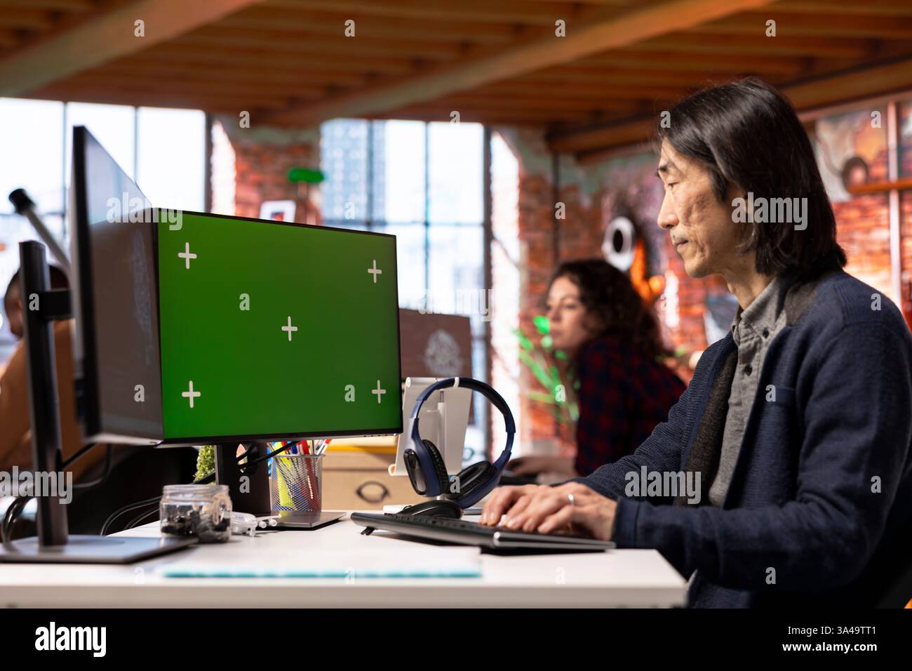 Senior programmer using green screen PC working with artificial intelligence technology in tech ...