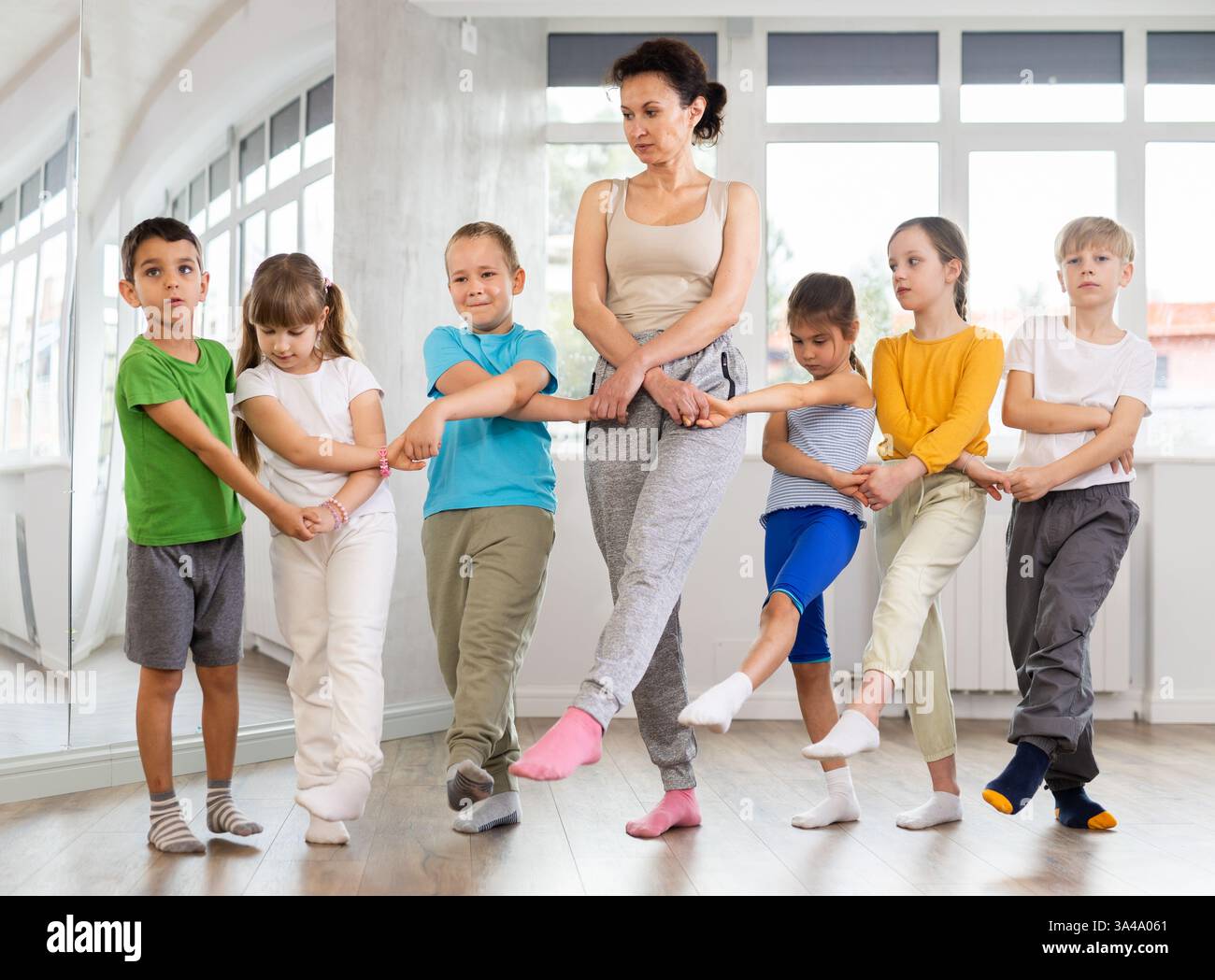Preteen children and doing cancan dance together with female trainer ...
