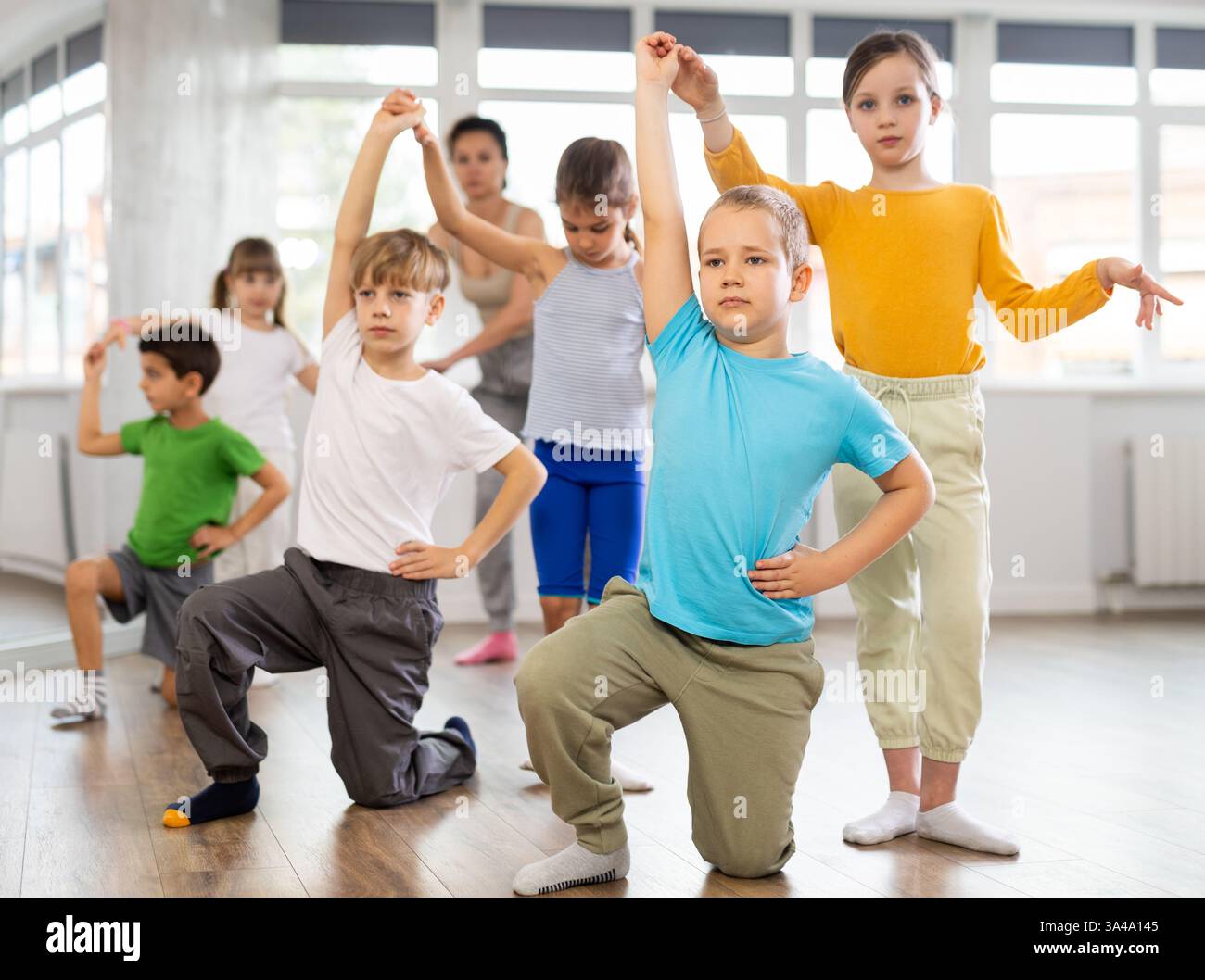 Happy preteen children practicing ballroom dances in pairs in training ...