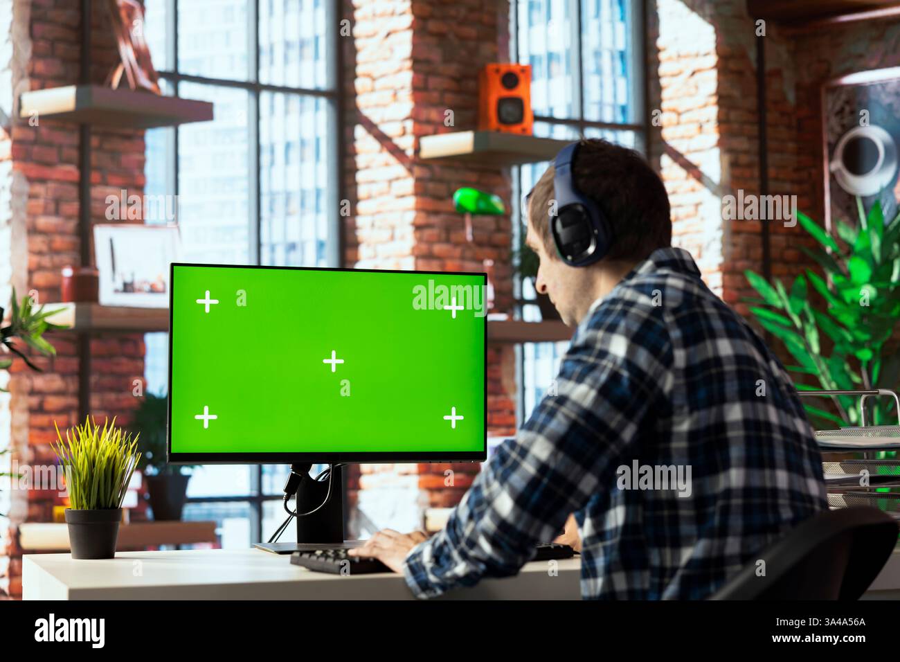 Employee listening music at home office desk, using chroma key computer ...
