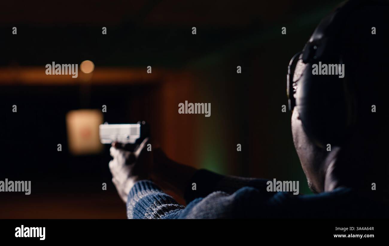 Person wearing safety glasses loading pistol ammo magazine during ...