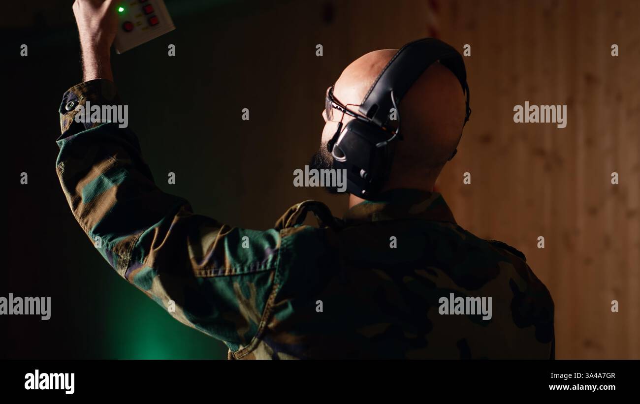 Cheerful army unit in firing range shooting targets with pistol pleased ...