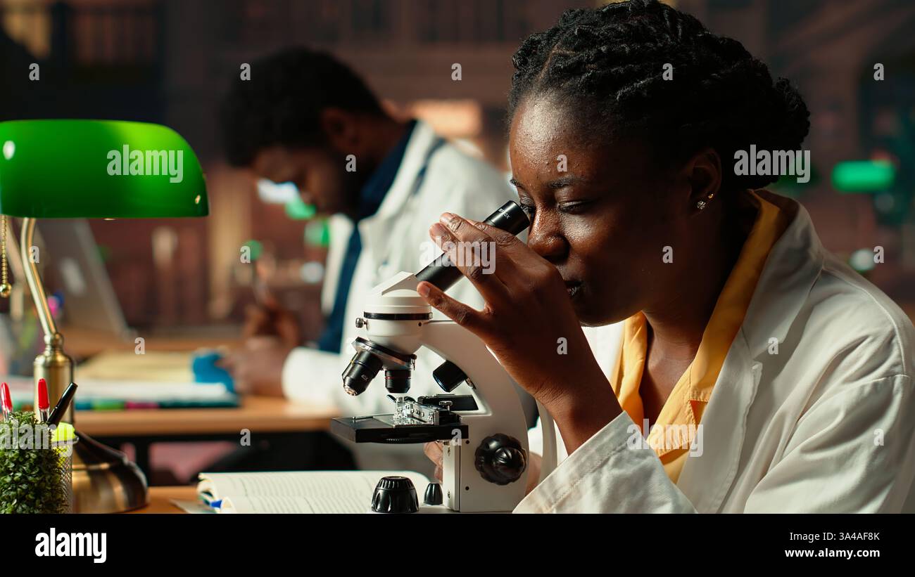 Female science student examines cells under the microscope for her ...