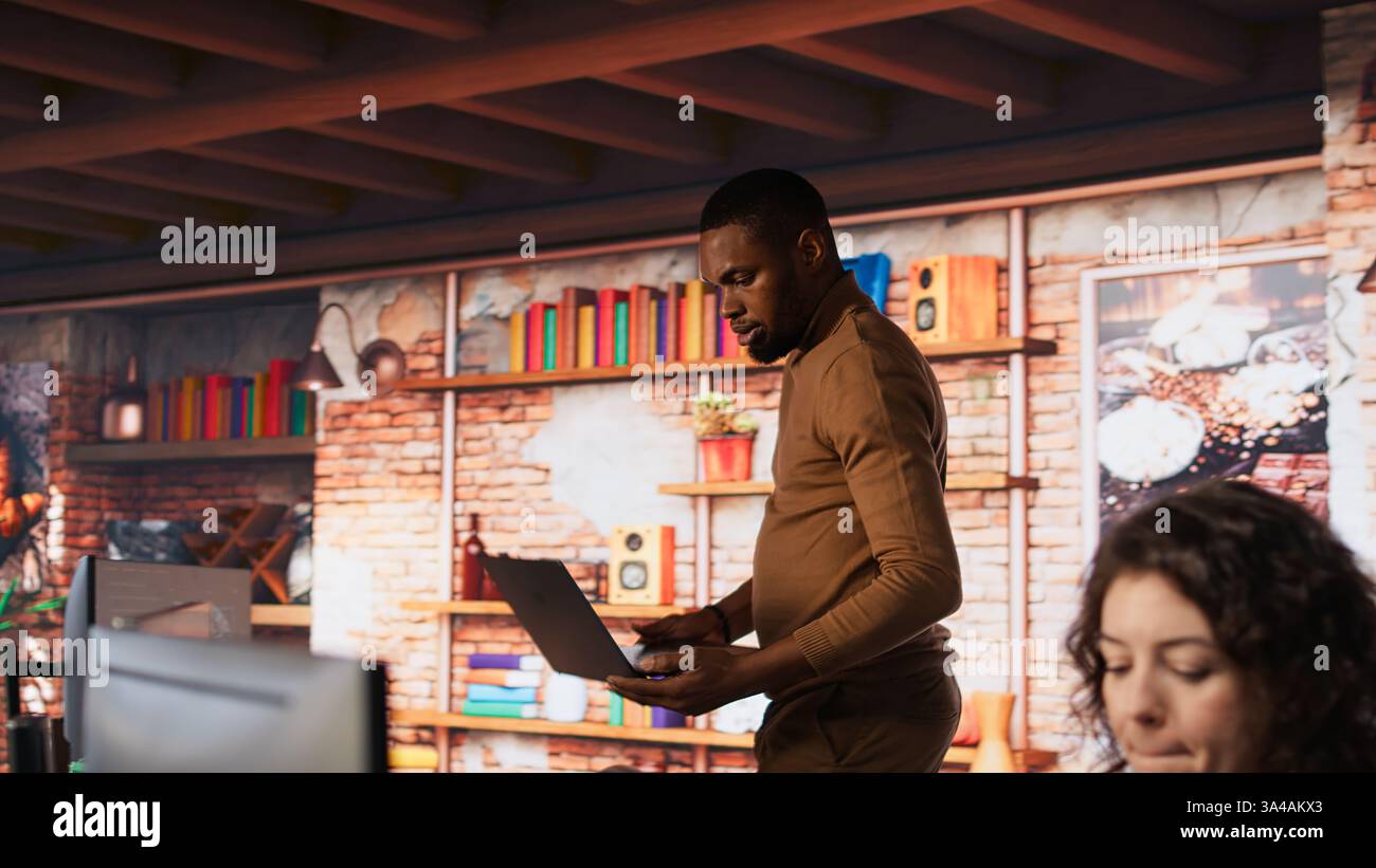 Startup employee coming at work with notebook, conducting code review to fix bugs, identifying ...