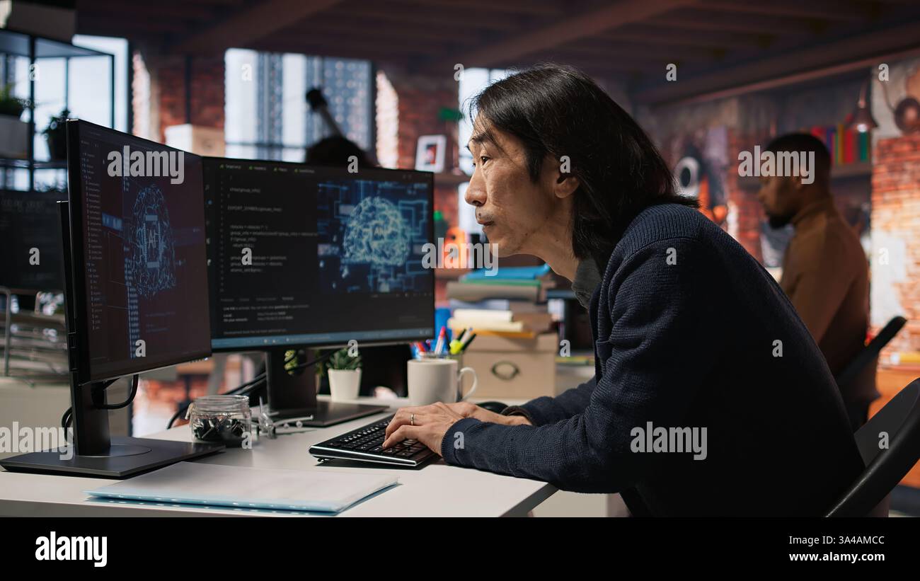 Software engineer in small business workspace using computer to oversee artificial intelligence ...