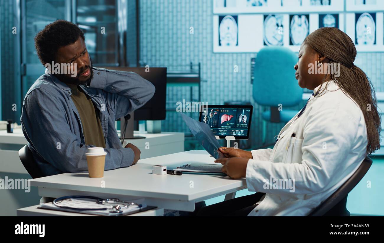 Medical interaction between a doctor and male patient with spinal pain ...