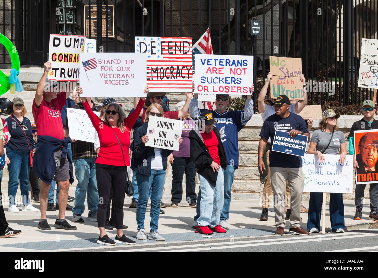 Atlanta, GA / USA - March 14, 2025: A group of people hold up signs ...