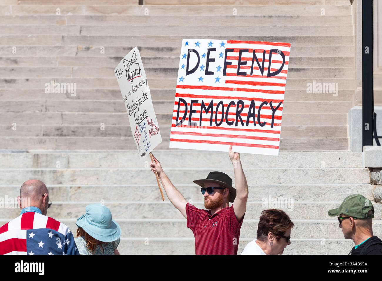 Atlanta, GA / USA - March 14, 2025: A man holds sign that says "Defend ...