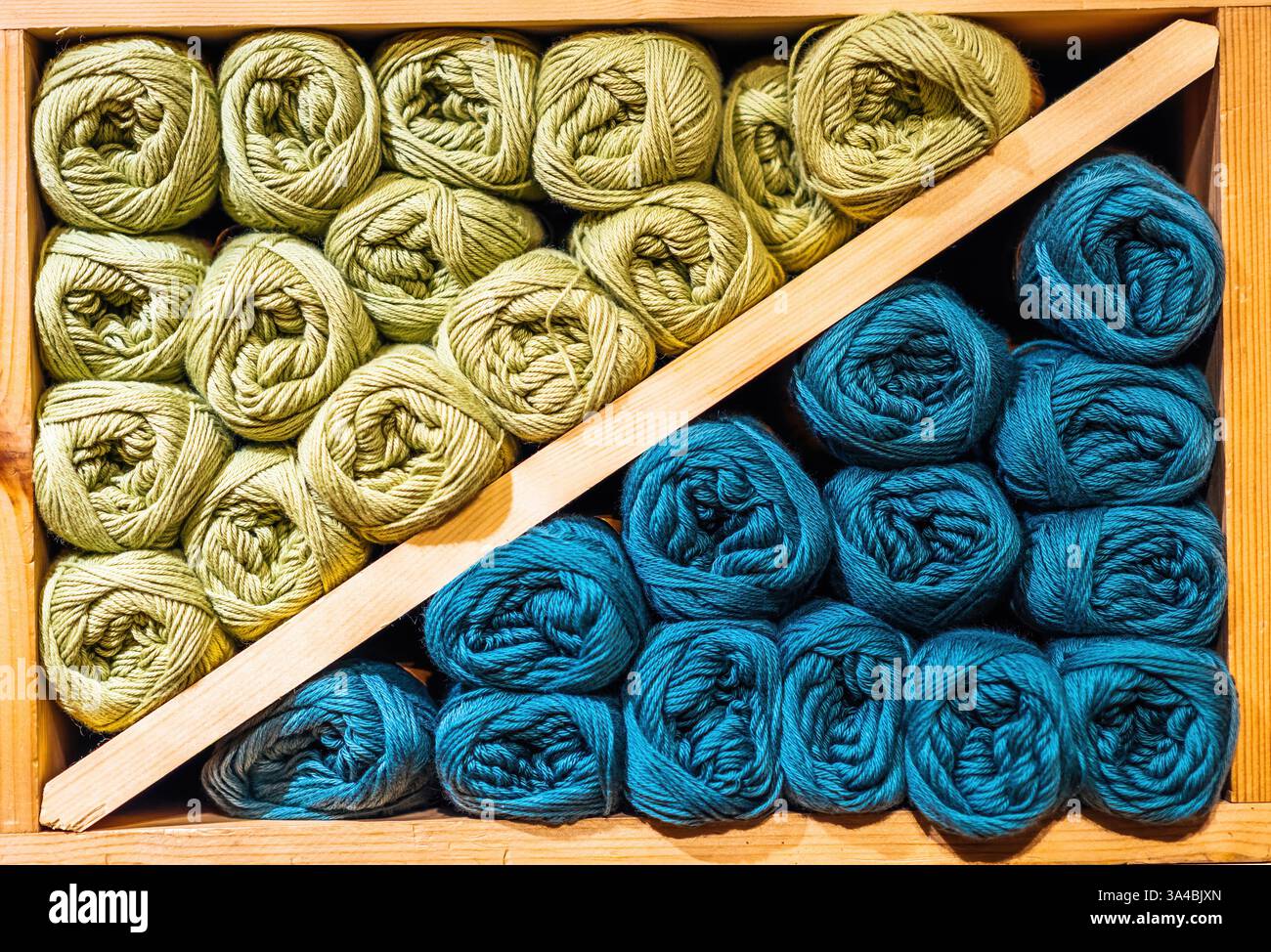 Brightly colored yarn balls neatly arranged in wooden compartments ...