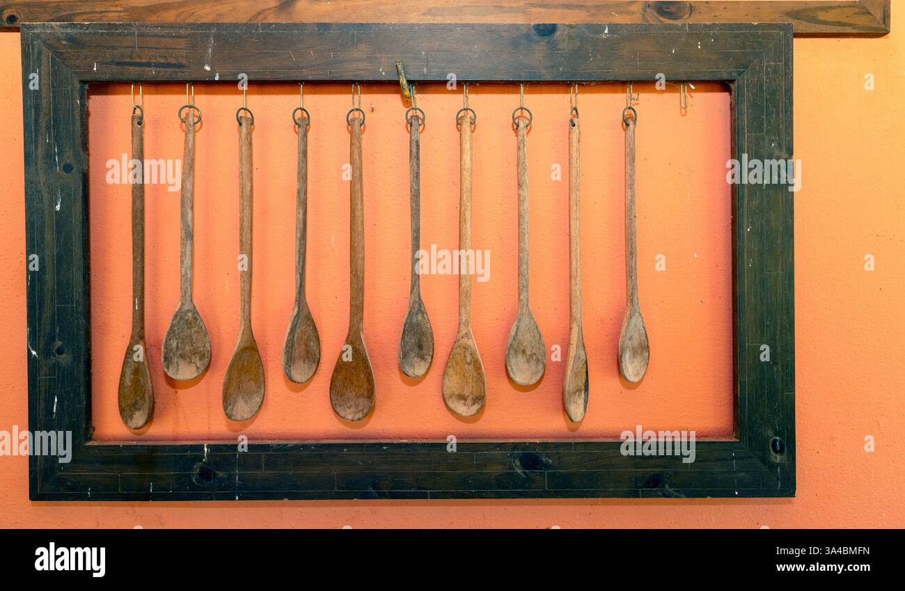 Wooden kitchen utensils frame on a wall background. Wooden spoons ...