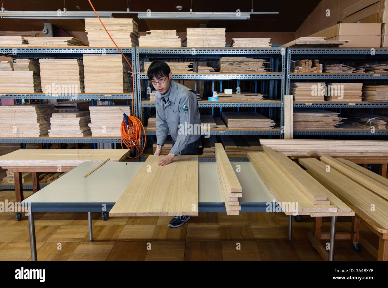 A craftsman aligns the lengths of kiri wood in preparation for ...