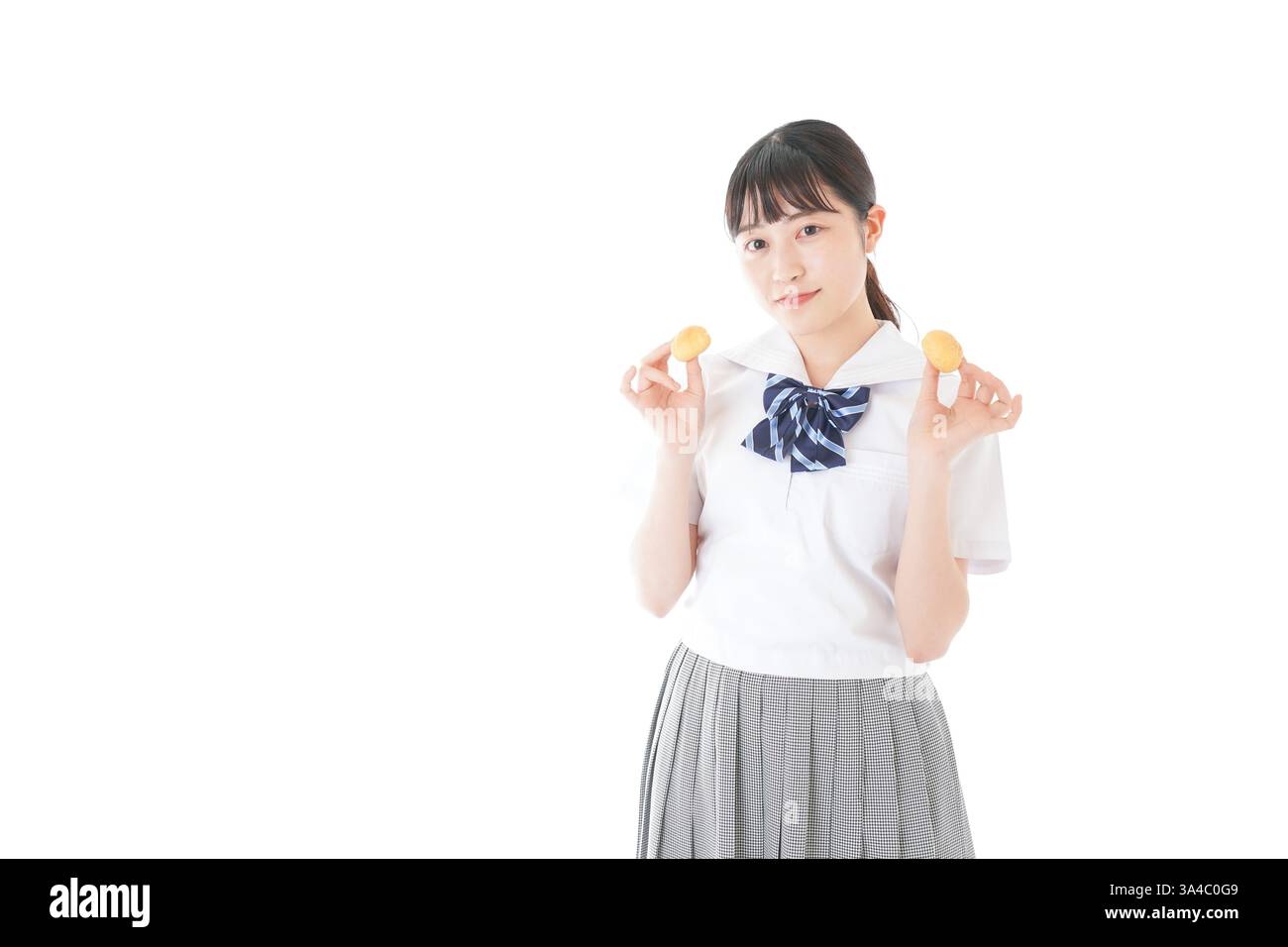 Schoolgirl in school uniform eating snack Stock Photo - Alamy